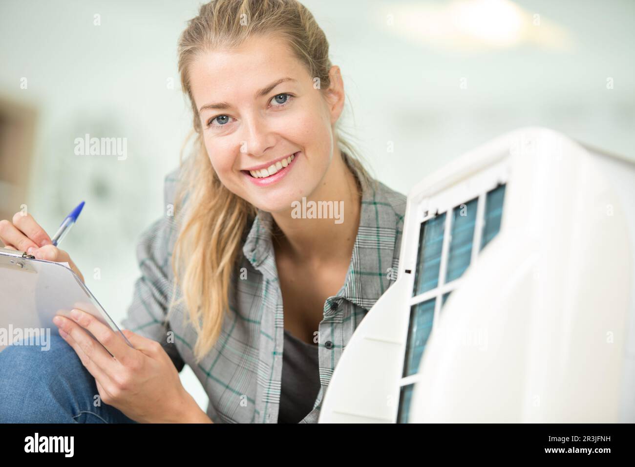 happy female worker repairing air conditioner Stock Photo - Alamy