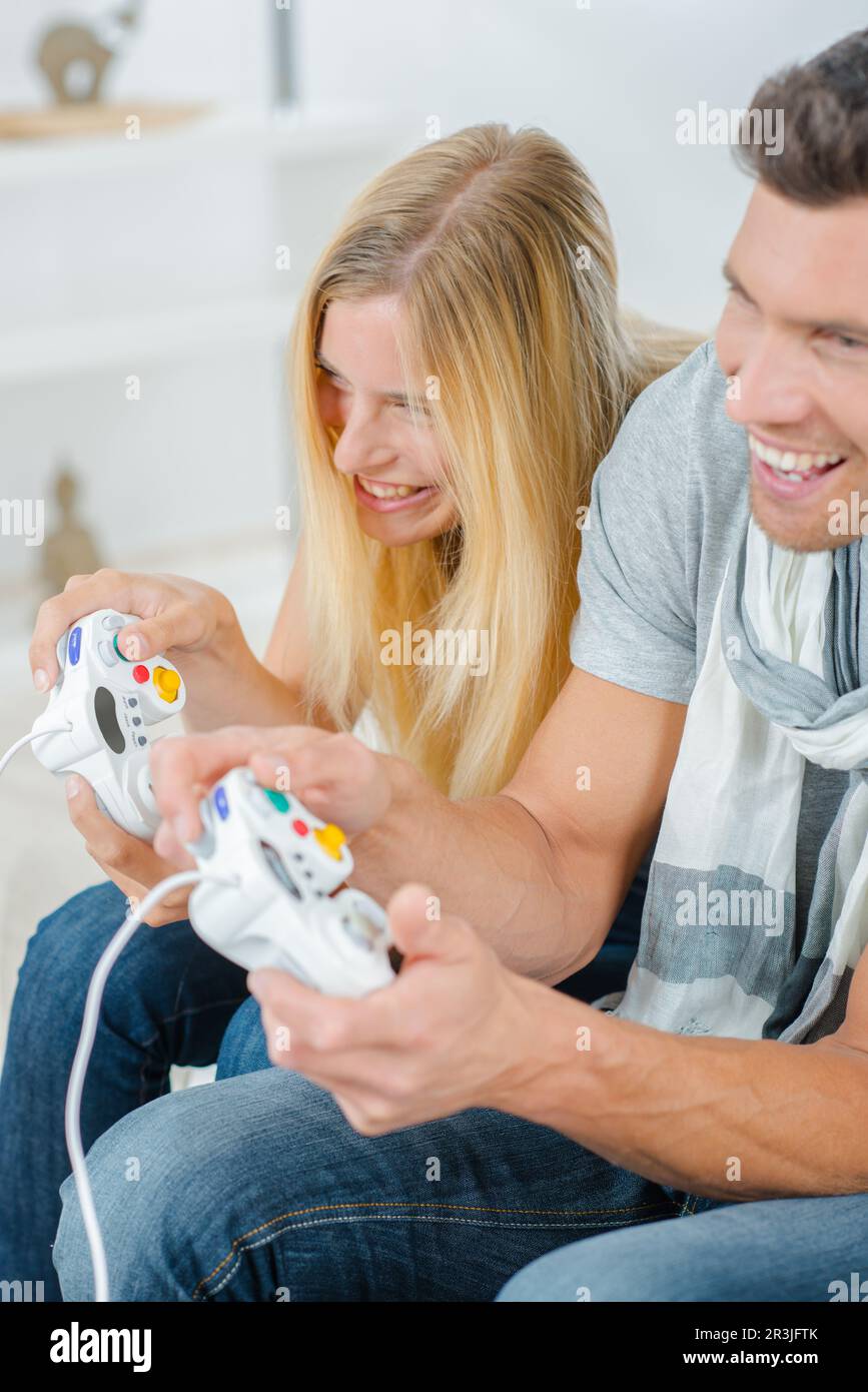 Couple at home playing computer game, leaning to one side Stock Photo ...