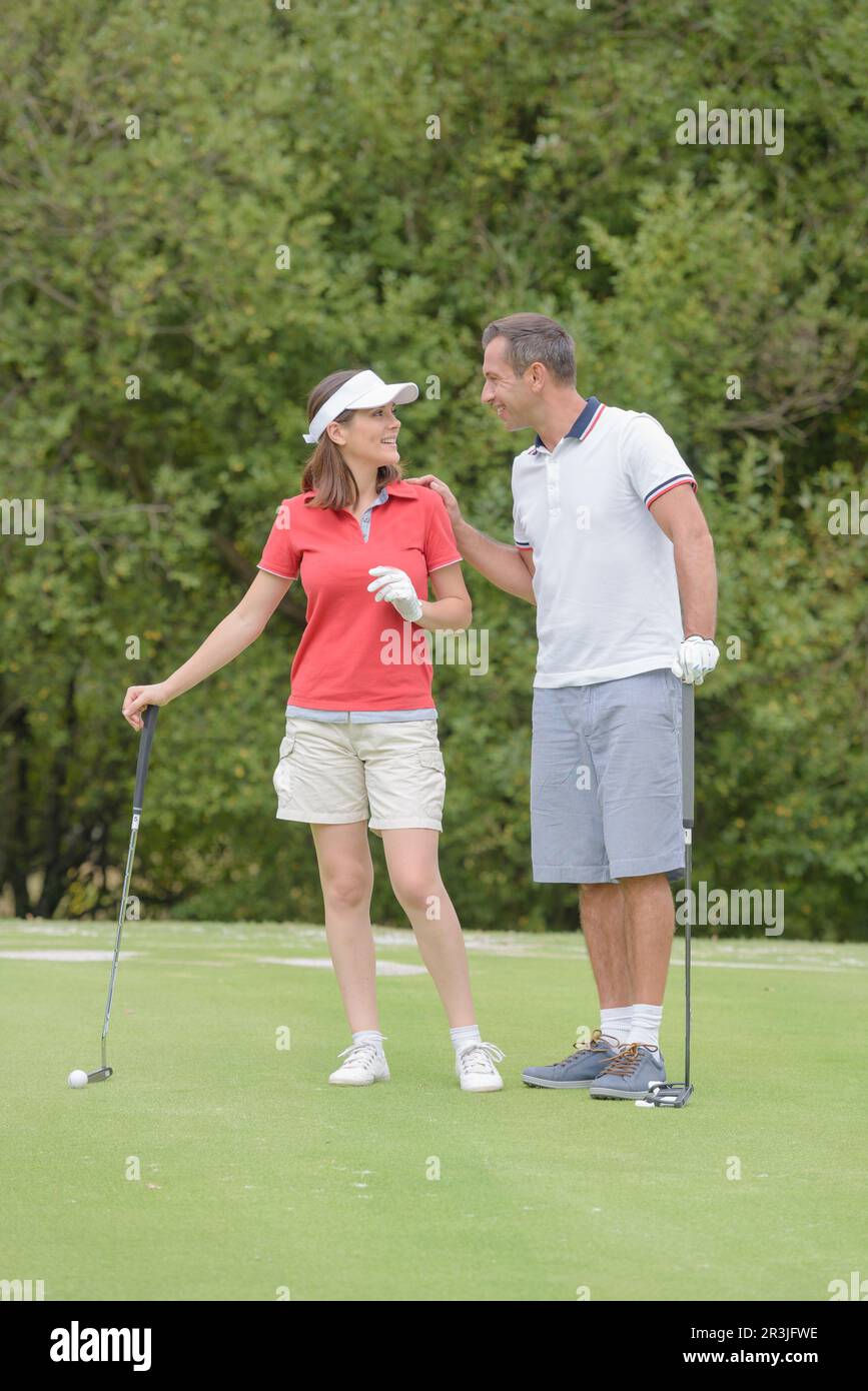 happy golfing couple with golf bag on green field Stock Photo - Alamy