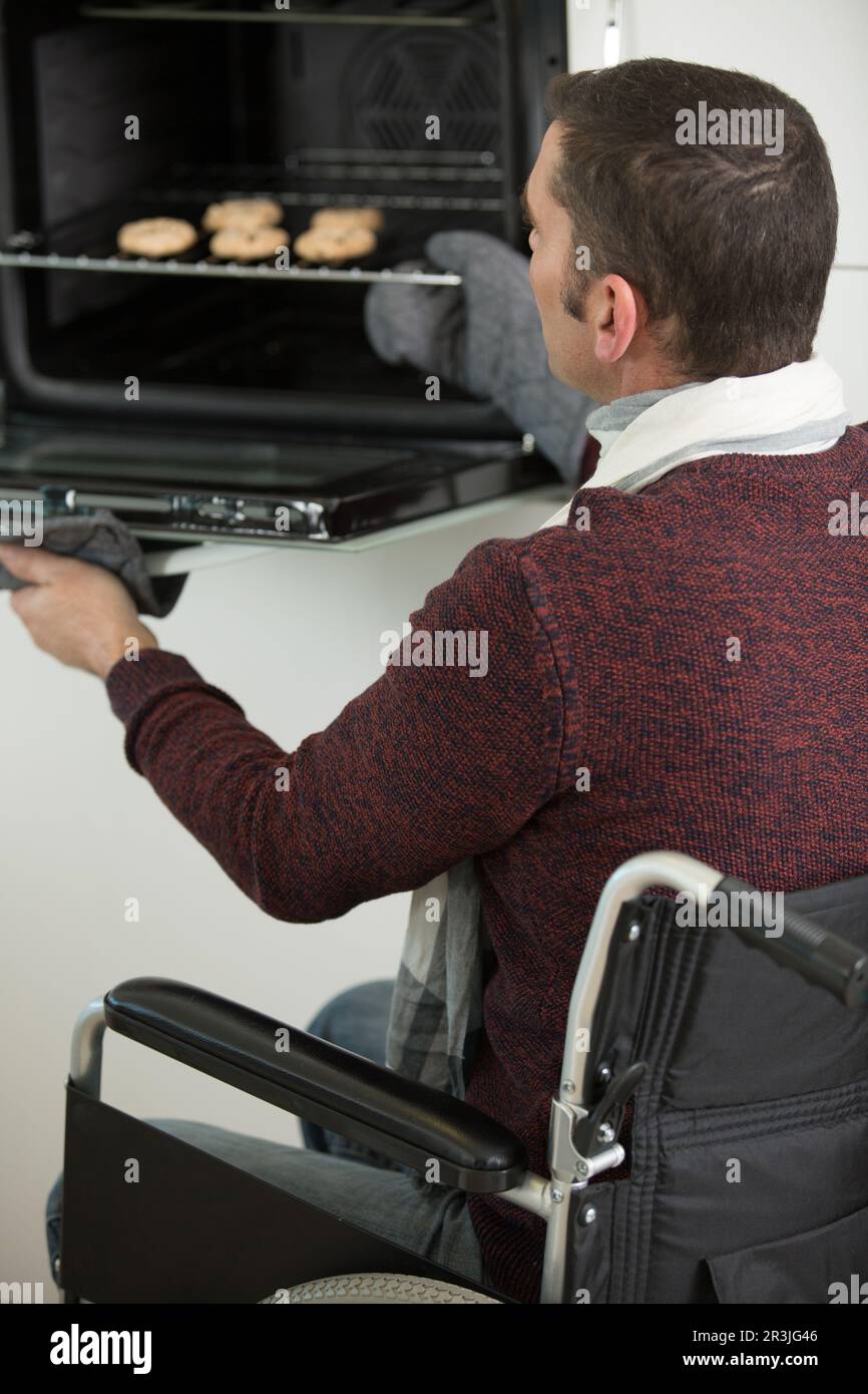 disabled baker taking food from oven Stock Photo - Alamy