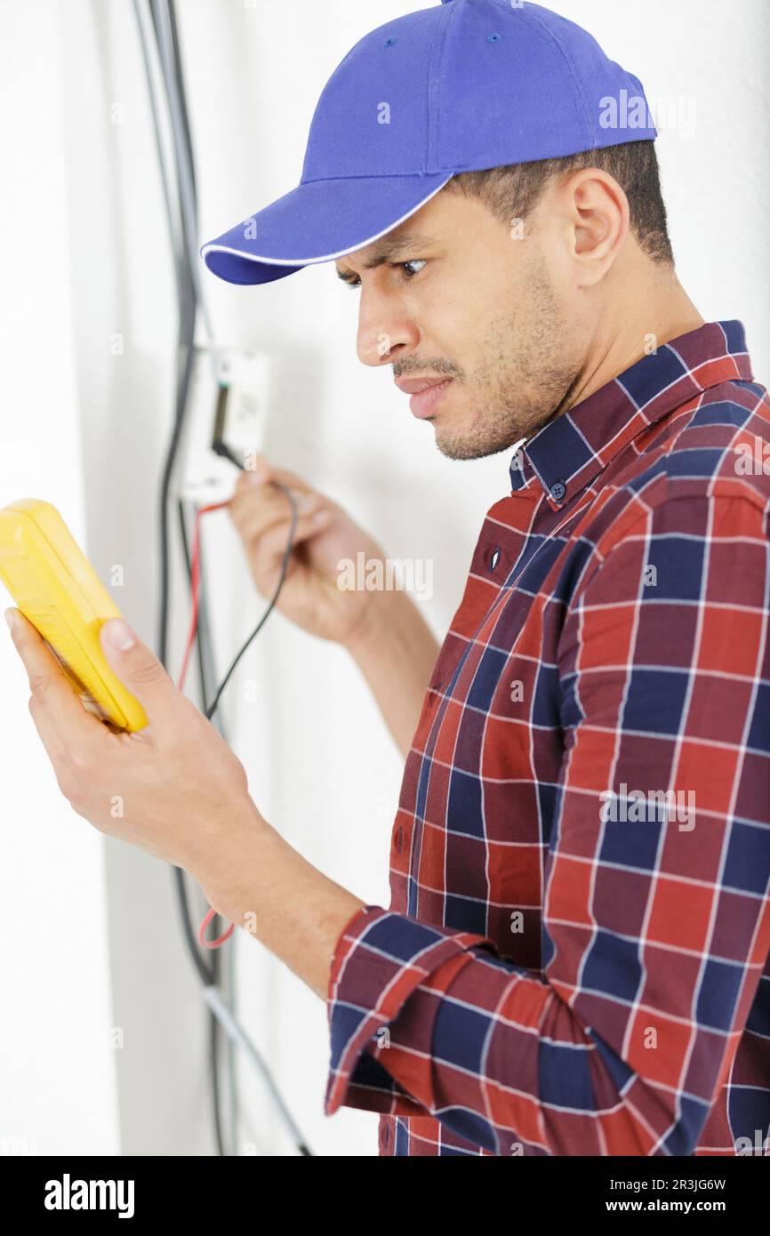 electrician at work measures the electric current Stock Photo - Alamy