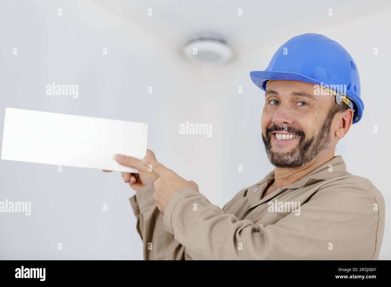 construction worker holding blank advertising banner Stock Photo - Alamy