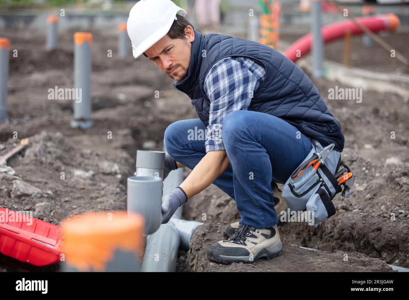 builder man installing pvc pipes outdoors Stock Photo - Alamy