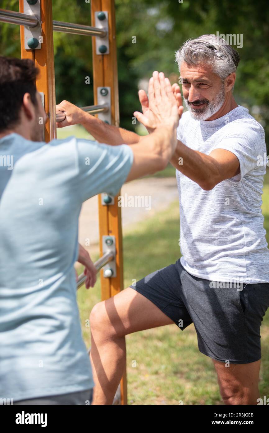 men exercising in the park doing a high-five Stock Photo - Alamy