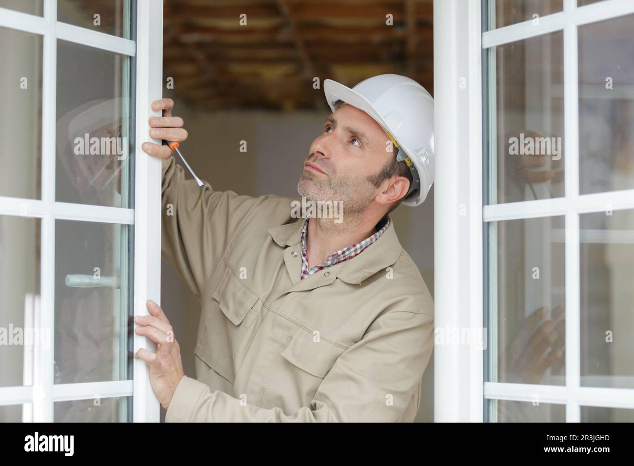 a craftsman installing a window Stock Photo - Alamy