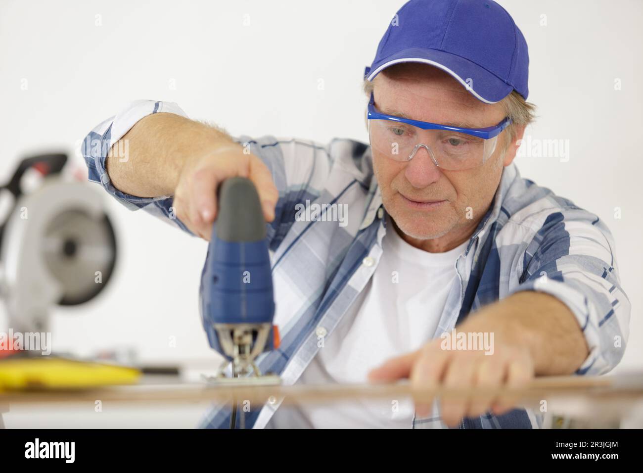 Senior craftsman sawing wood hi-res stock photography and images - Alamy