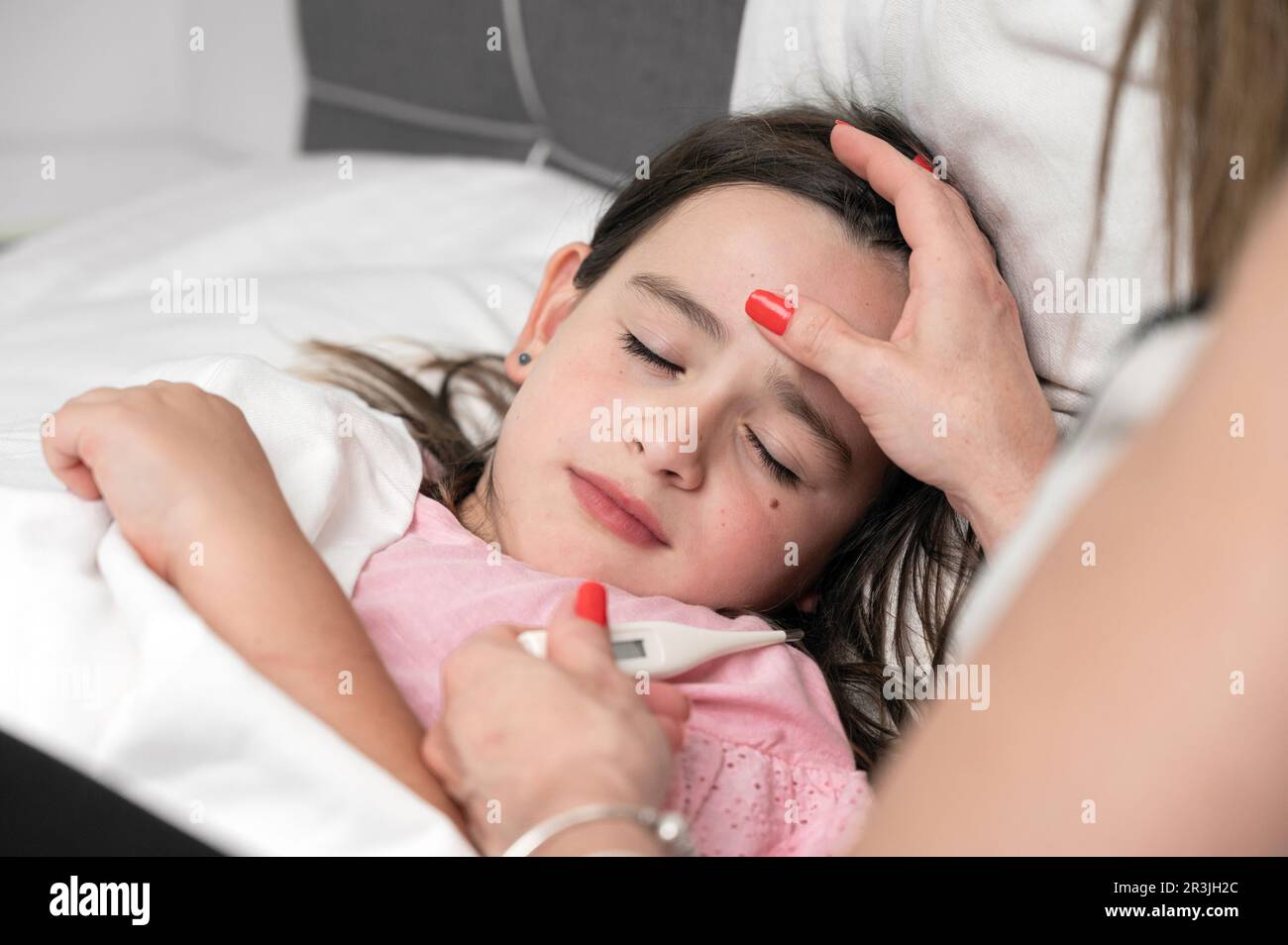 Mother taking care of her sick daughter Stock Photo - Alamy