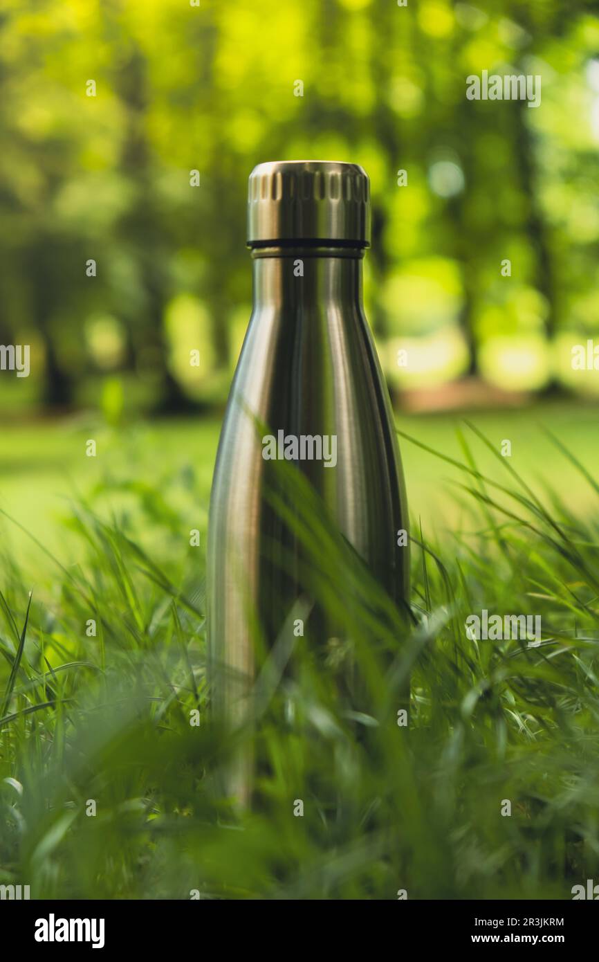 Water bottle. Reusable steel thermo water bottle on green grass ...
