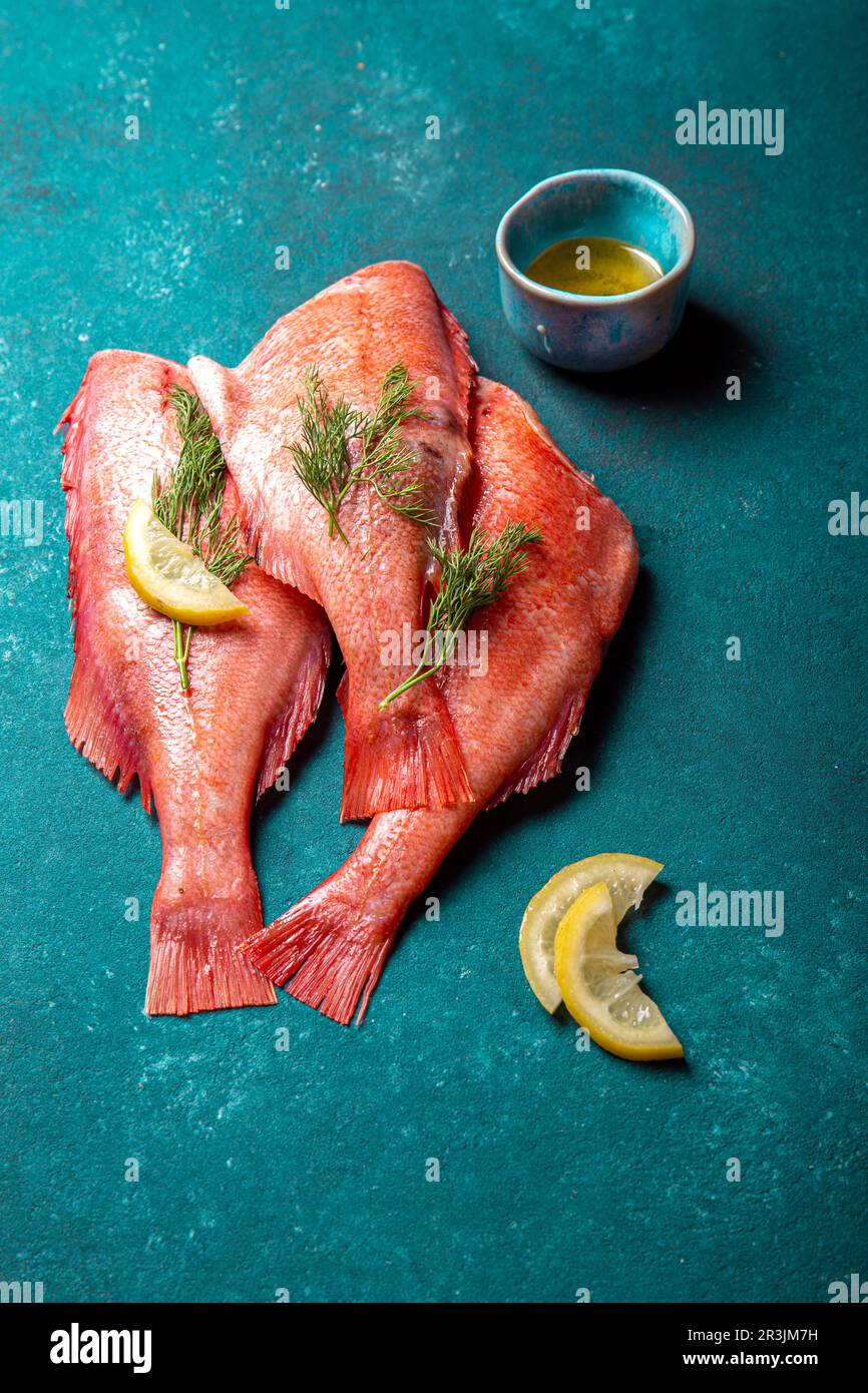 Fresh red sea bass on blue background Stock Photo - Alamy