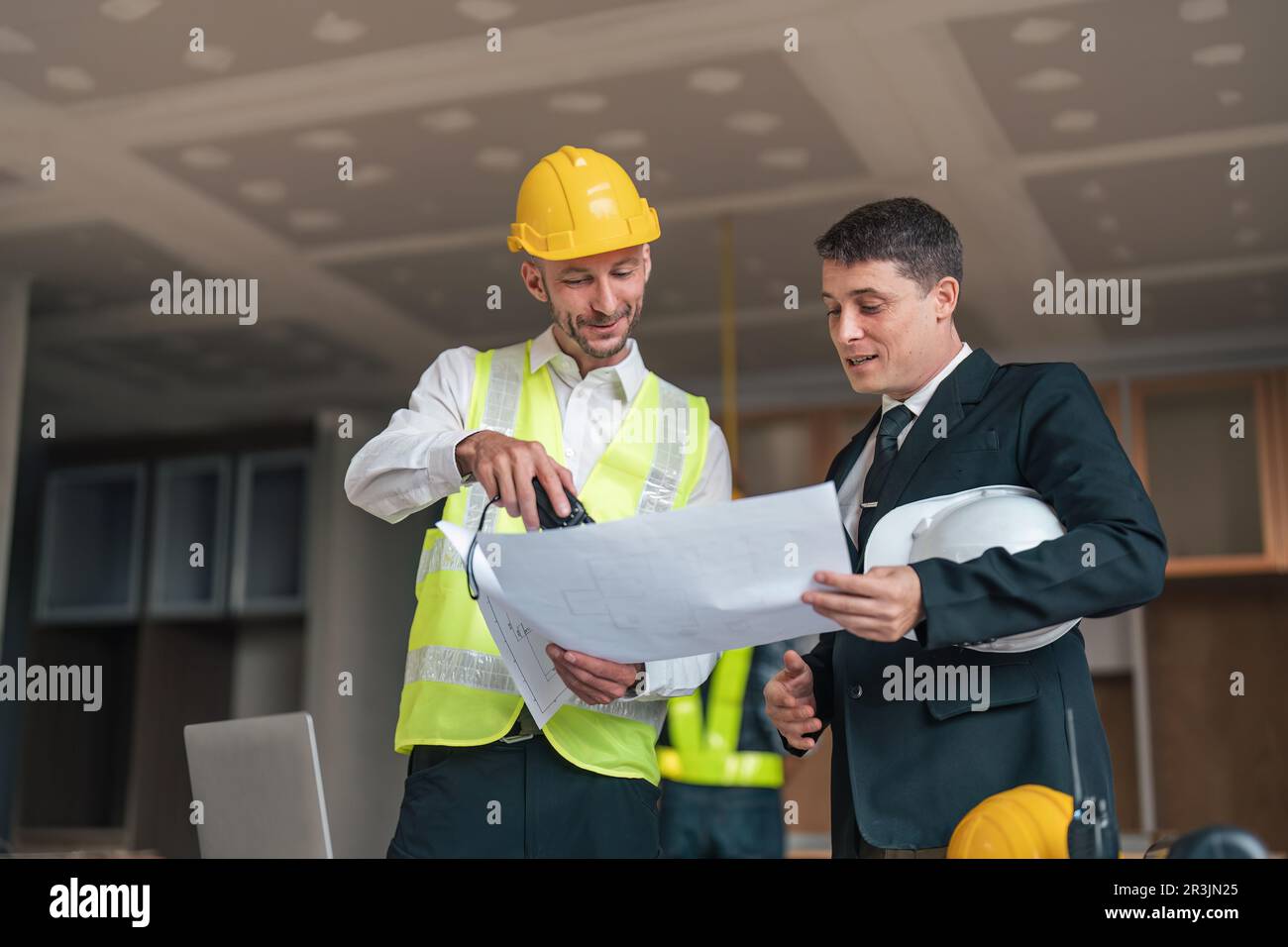 Professional construction engineers team using blueprint of project ...