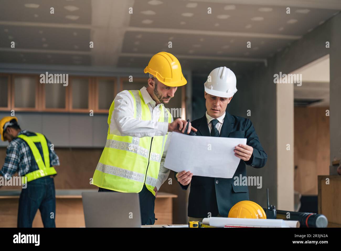 Professional construction engineers team using blueprint of project ...