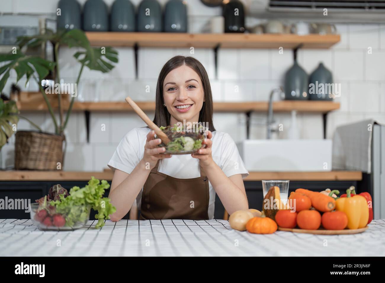 Vegetable woman relaxes at home, cooks in kitchen. Healthy concept ...