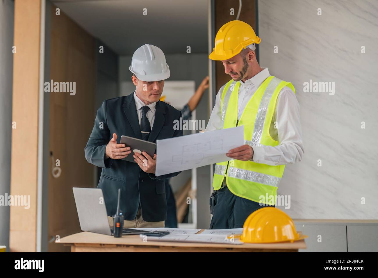 Professional construction engineers team using blueprint of project ...