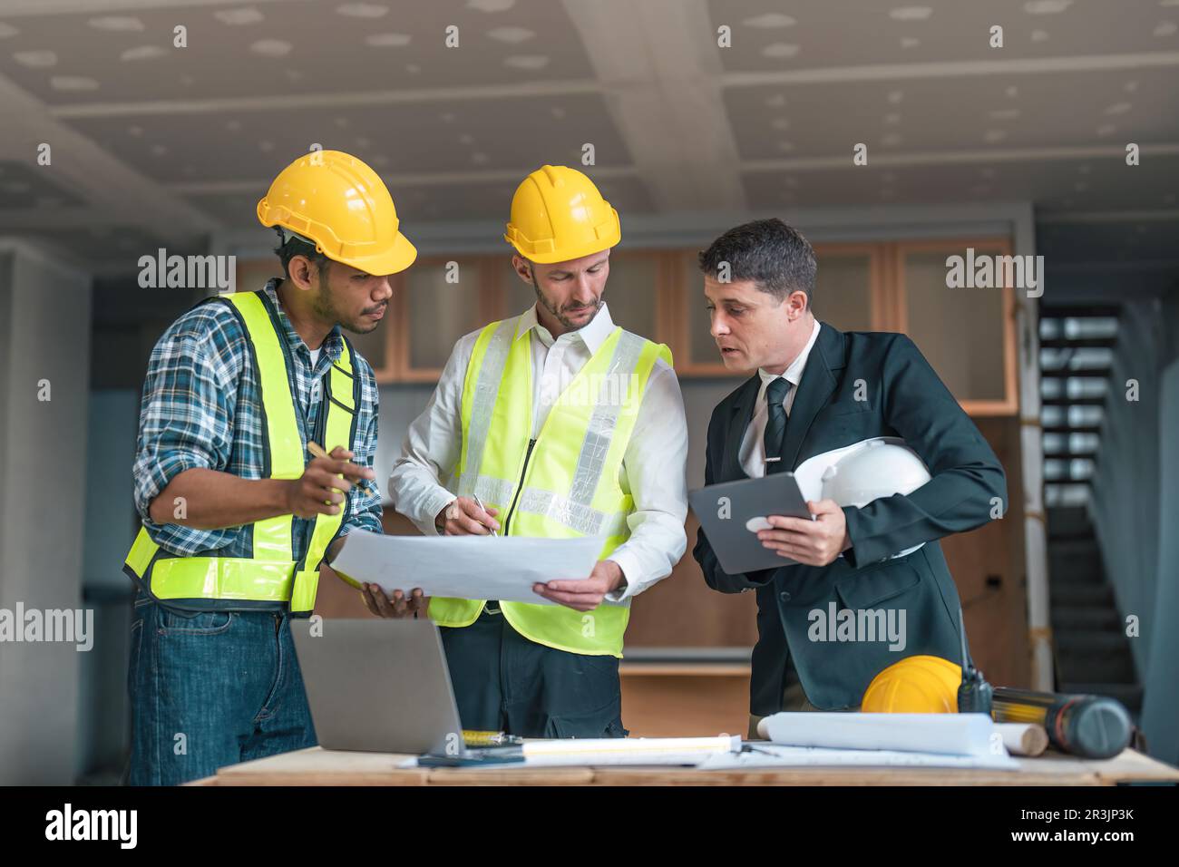 Professional construction engineers team using blueprint of project ...