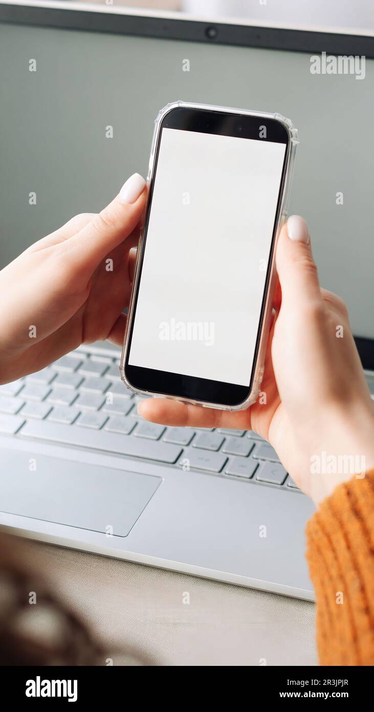 Over shoulder view of woman holding mobile phone with white blank mock ...