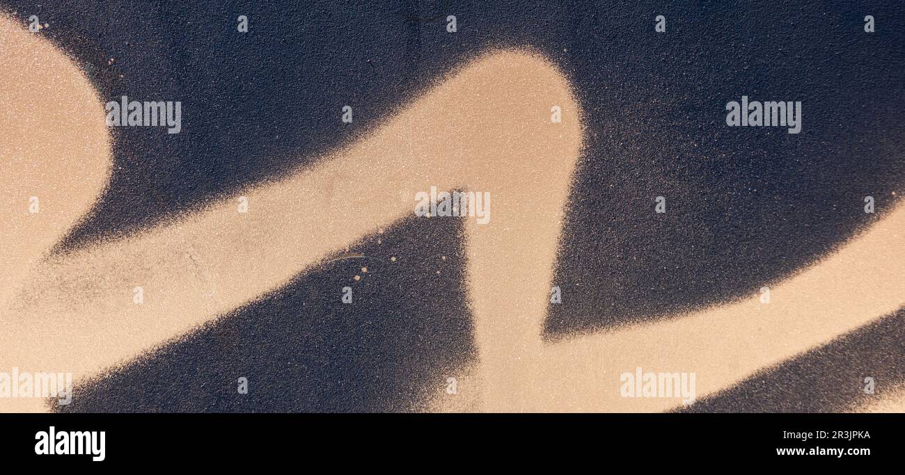 Messy paint strokes and smudges on old black painted wall. Light brown ...