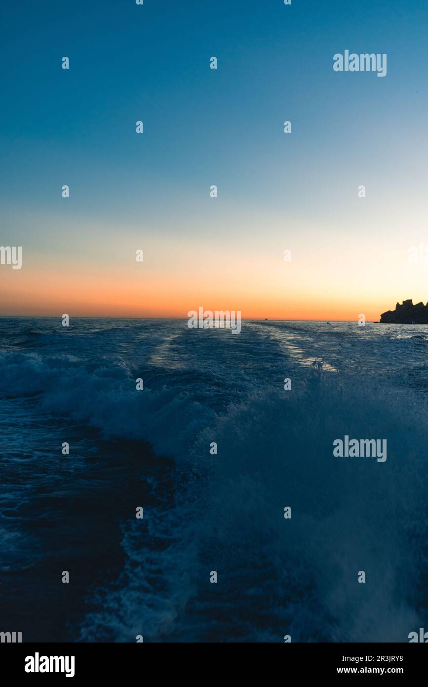Motorboat wake at sunset light Stock Photo - Alamy