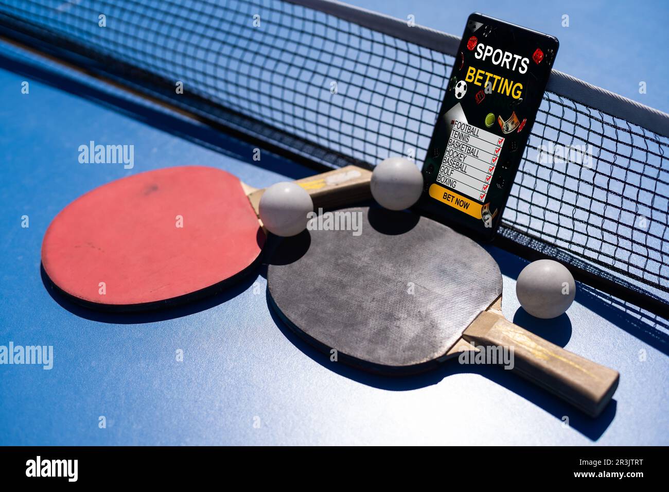 Smartphone on a blue table with ping pong rackets, rope and on ...