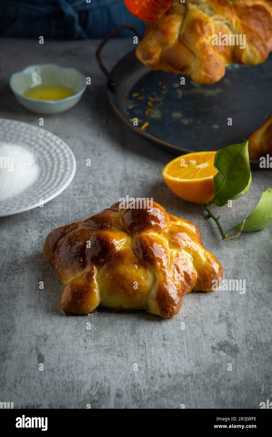 Woman preparing Pan de muertos bread of the dead for Mexican day of the ...