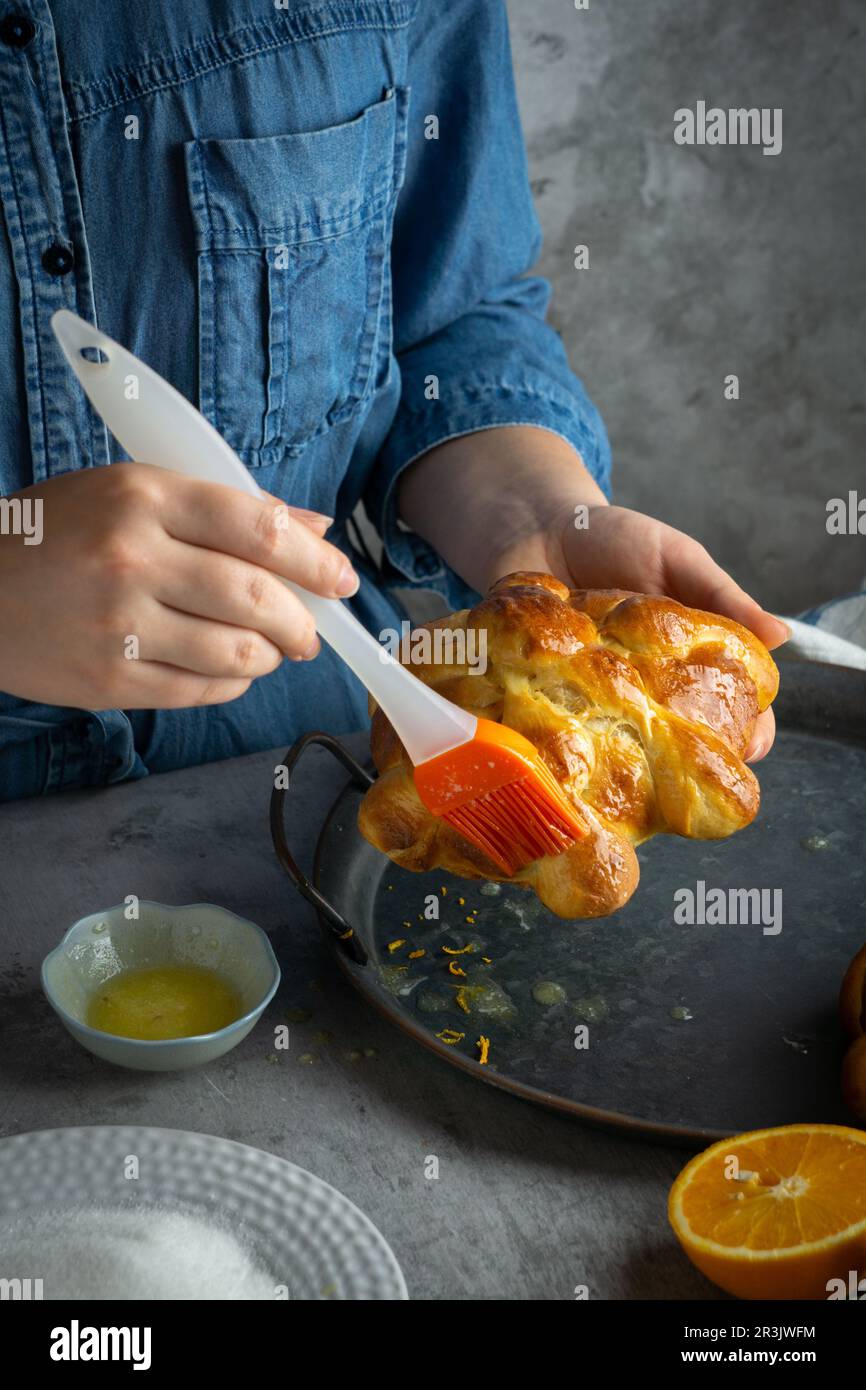 Woman preparing Pan de muertos bread of the dead for Mexican day of the ...