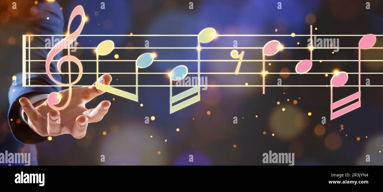 Musician holding staff with music notes and symbols on color background ...