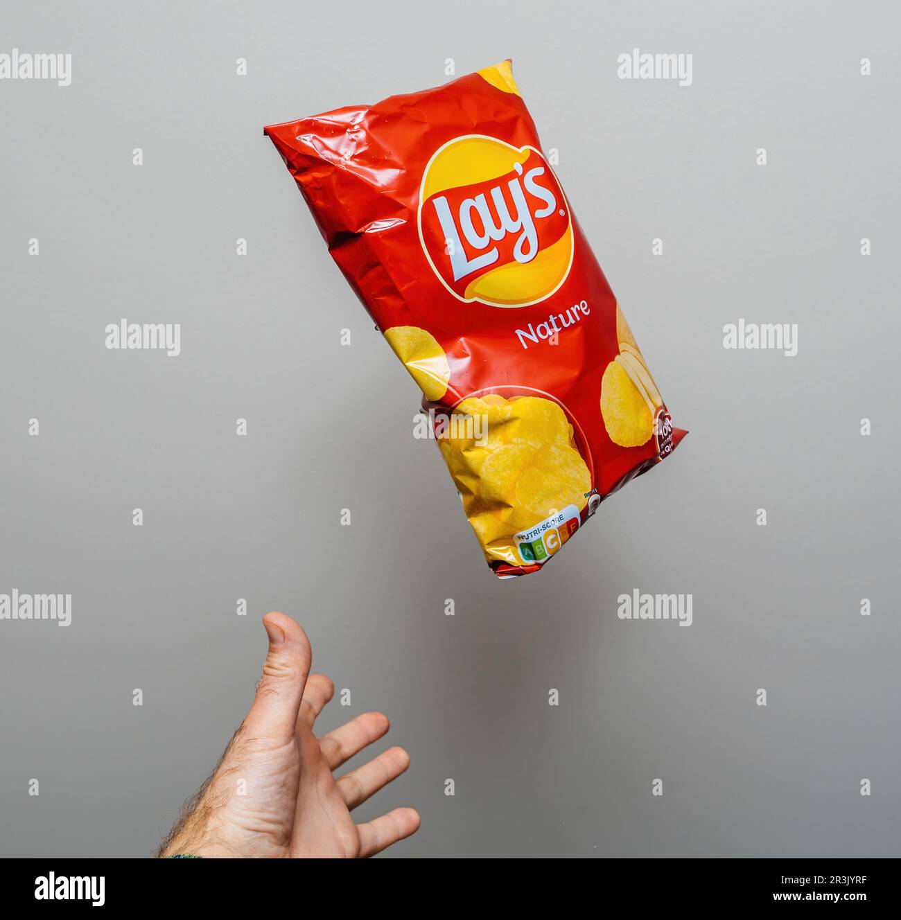 Lyon, France - May 24, 2023: Hand about to get package of Lays potato ...