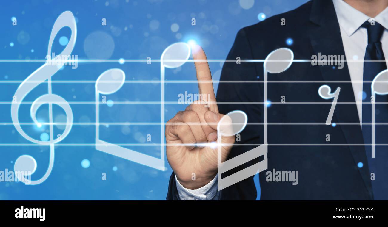 Musician pointing at staff with music notes and symbols on color ...