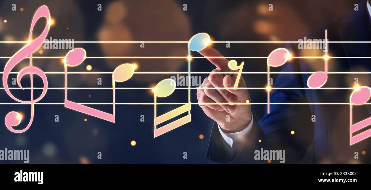Musician pointing at staff with music notes and symbols on color ...