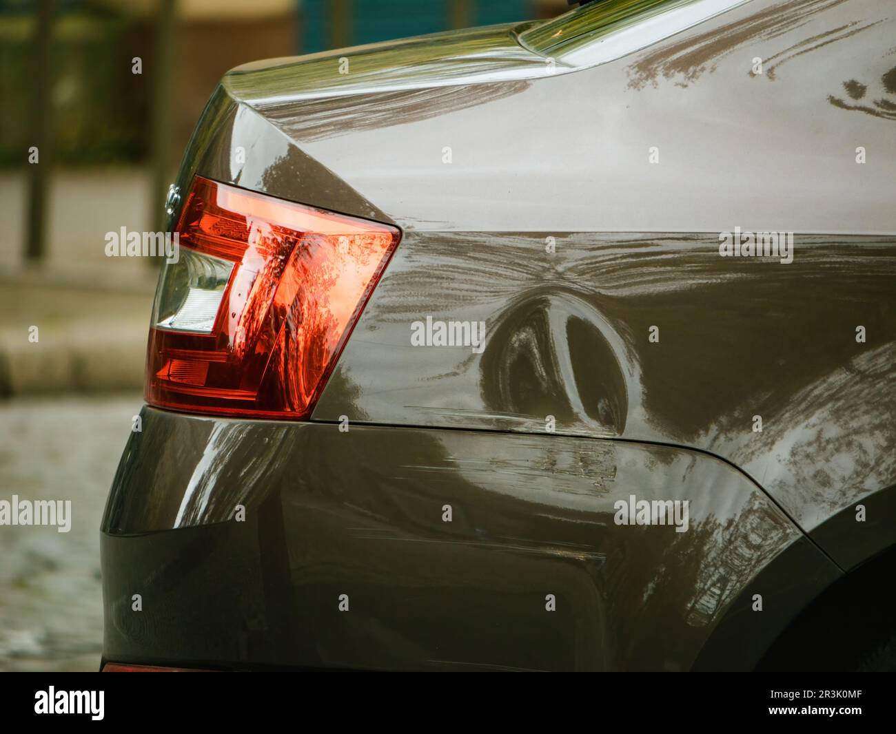 A damaged car after an accident parked in city, its rear wing scratched ...
