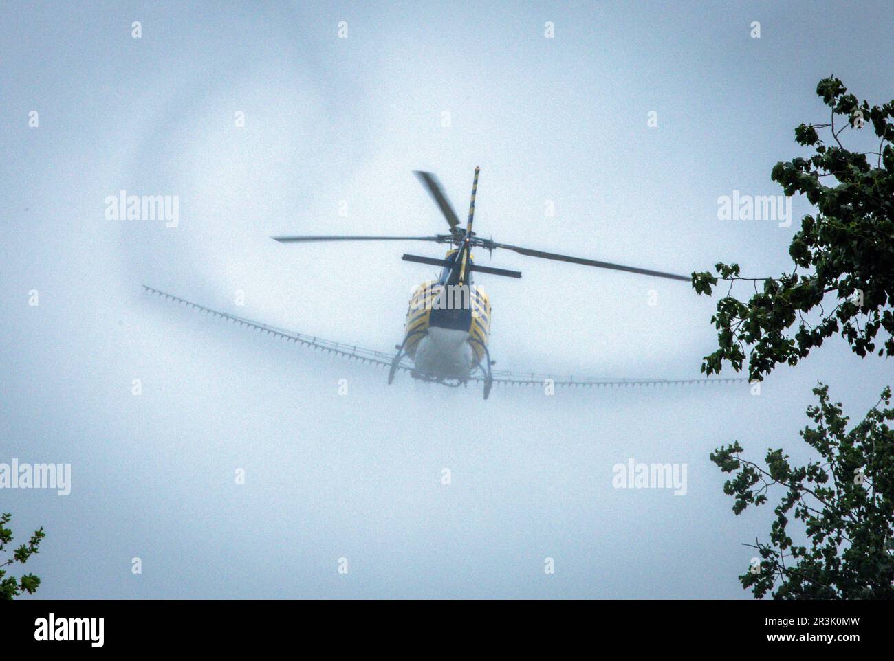Parchim, Germany. 24th May, 2023. A special helicopter sprays the ...