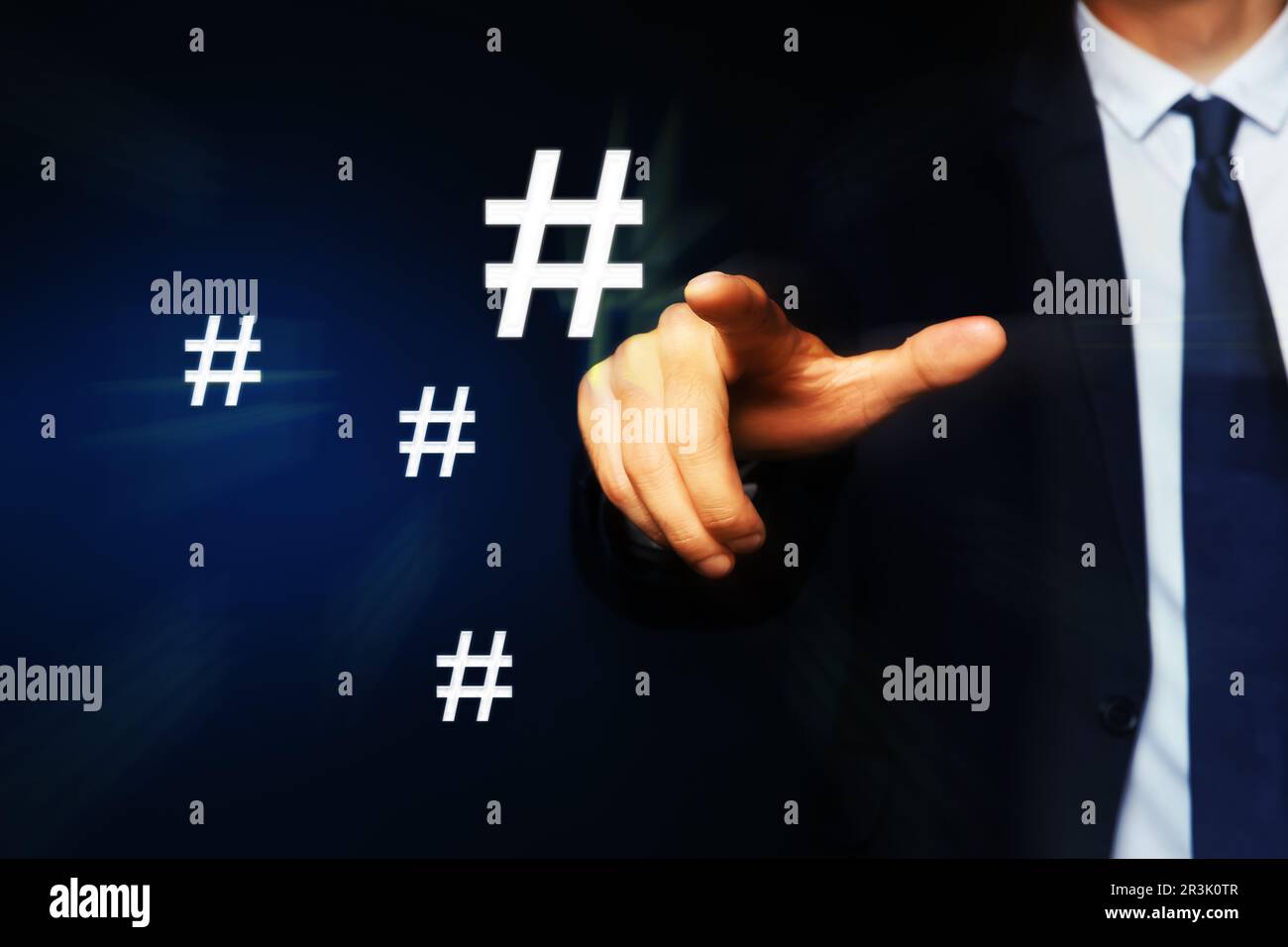 Hashtag concept. Man pointing at sign on dark blue background, closeup ...