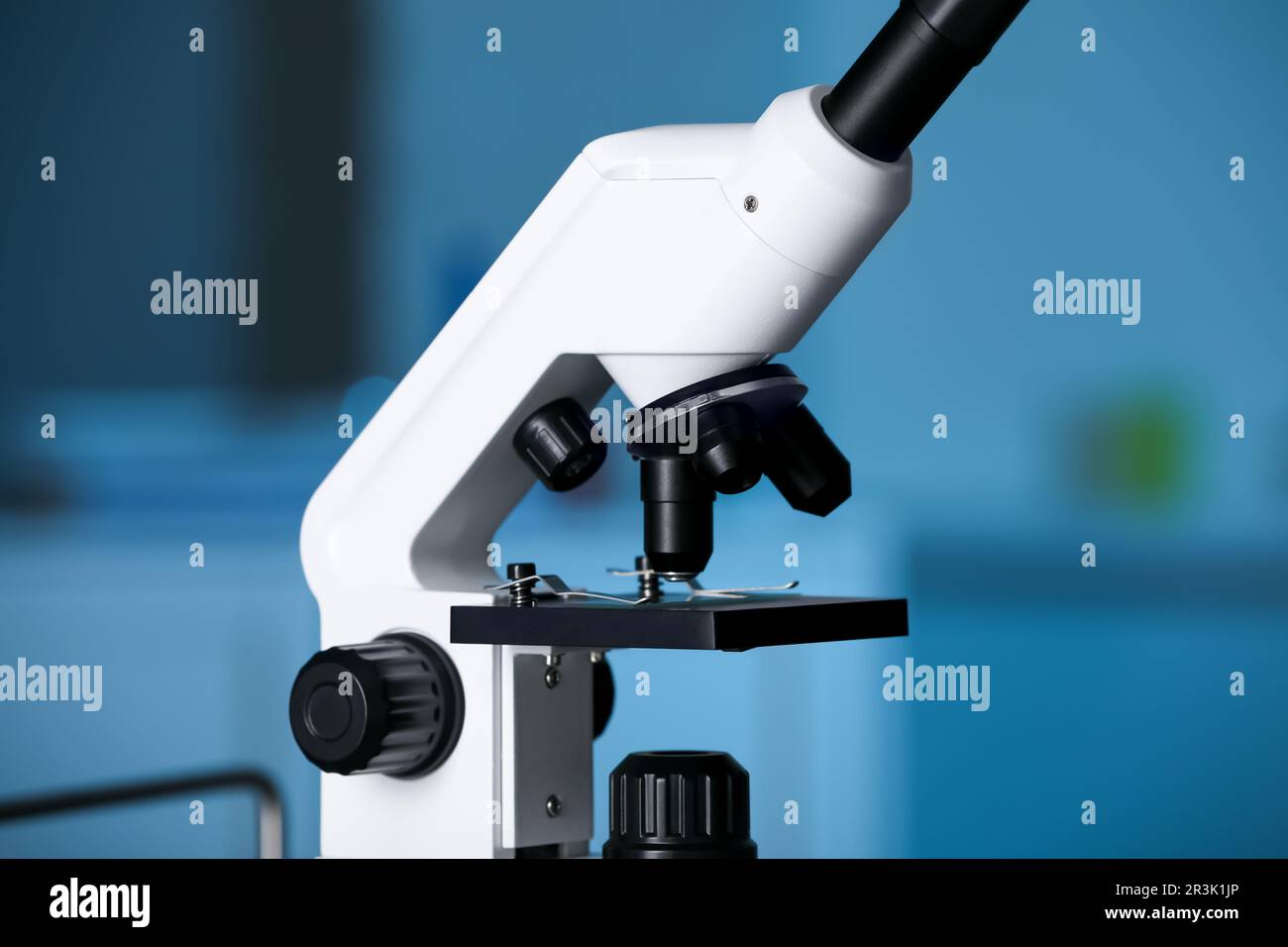 Modern medical microscope with glass slide on blurred background ...