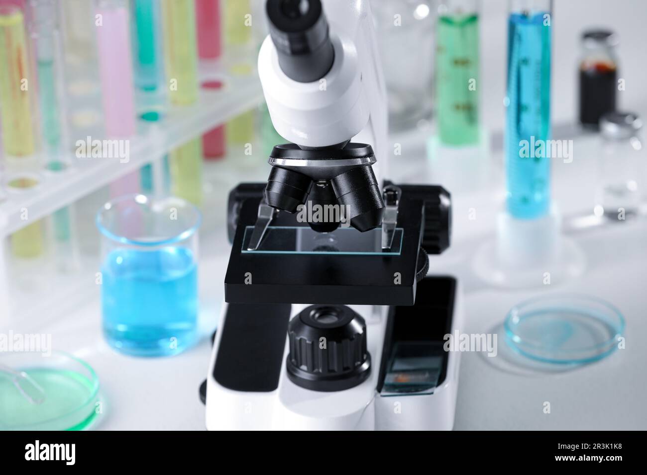 Modern microscope with glass slide on white table in laboratory ...