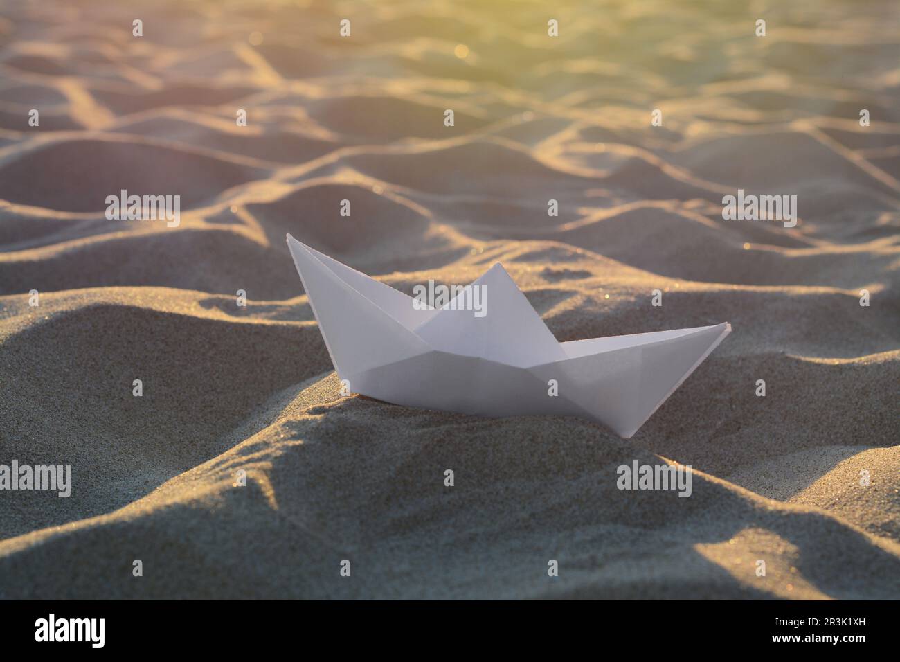 Beautiful white paper boat on sand outdoors Stock Photo - Alamy