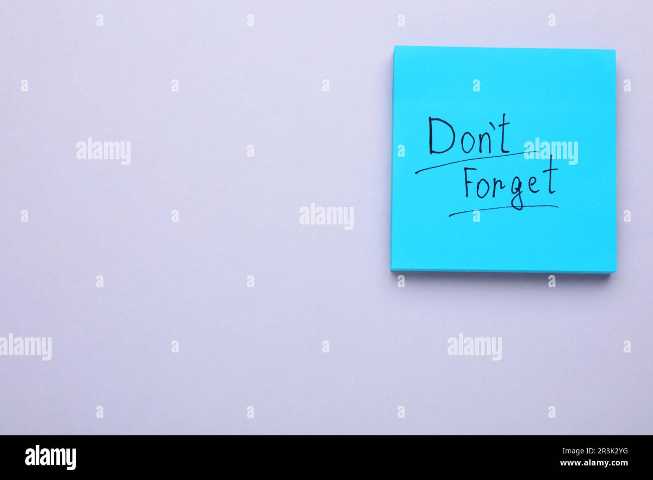 Paper note with phrase Don't Forget on light grey background, top view ...