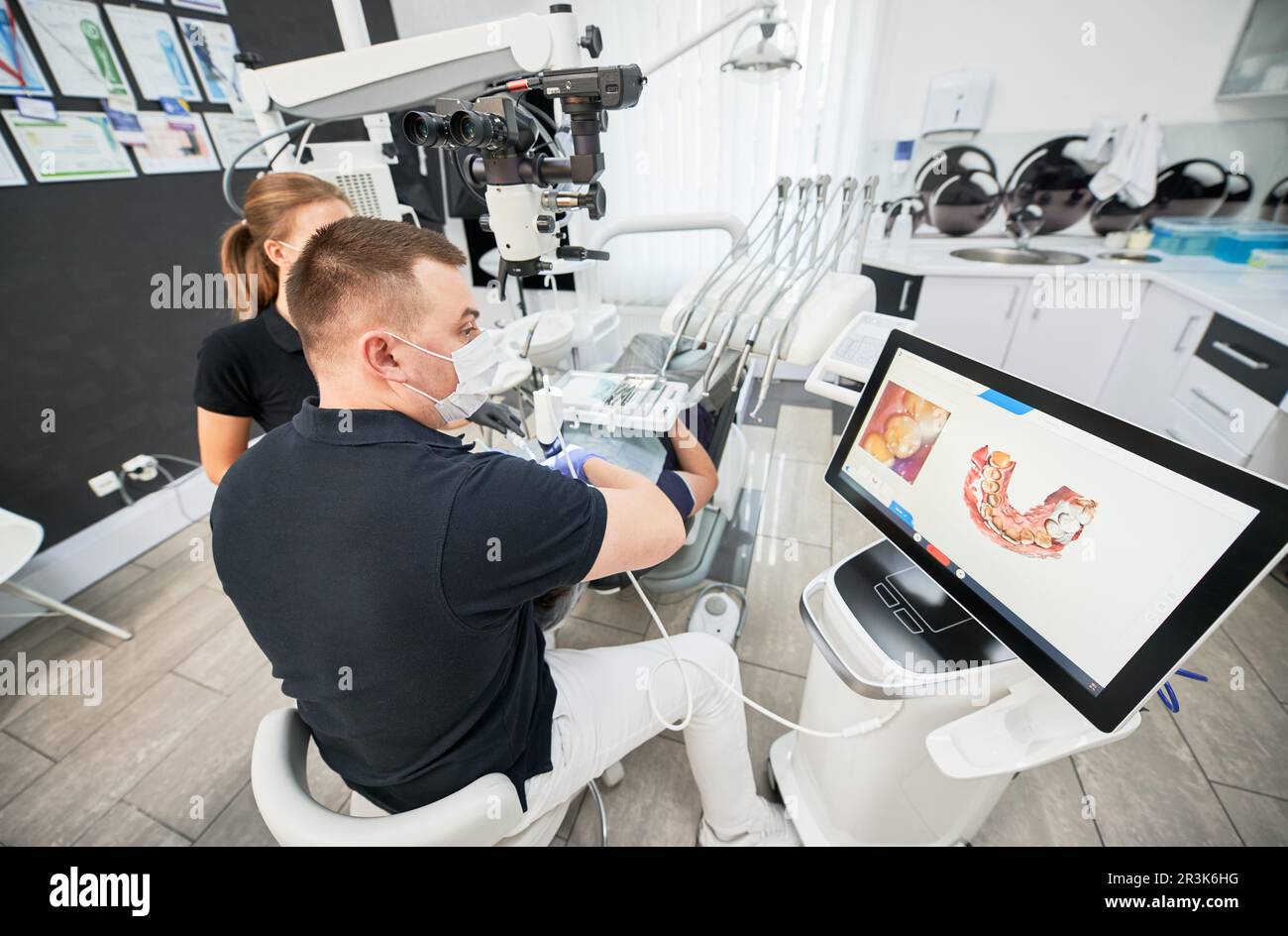 Dentist scanning patient's teeth with modern machine for intraoral ...