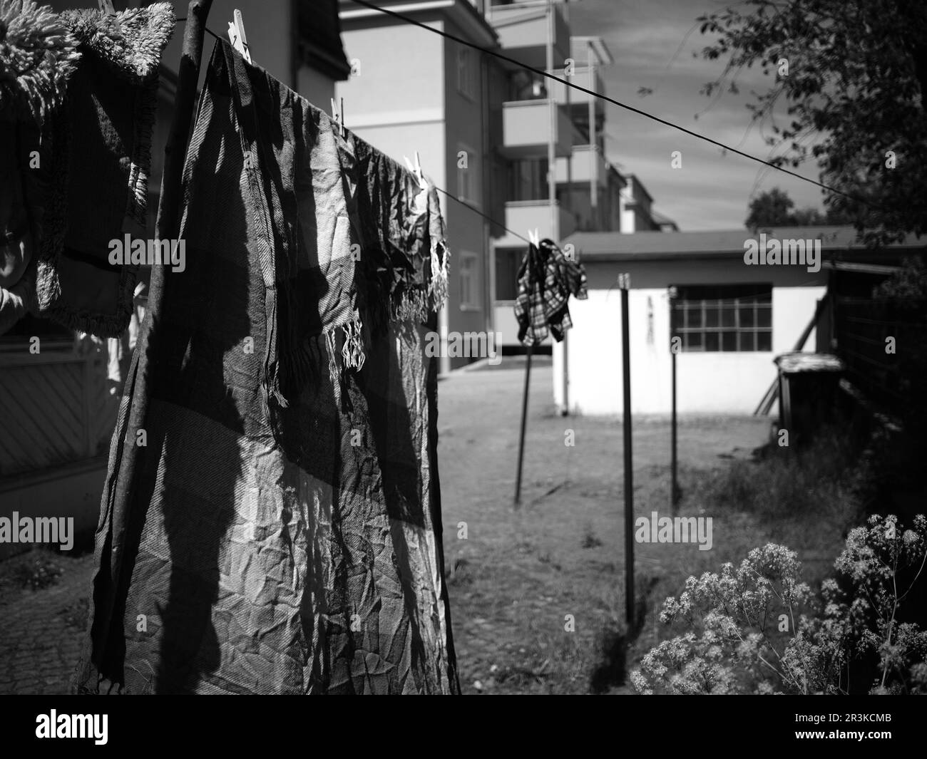 black and white picture of laundry drying on a wire outside of a ...