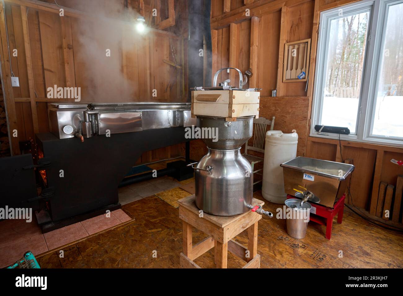Making maple syrup, 2nd filtration, in a sugar shack in a maple grove ...
