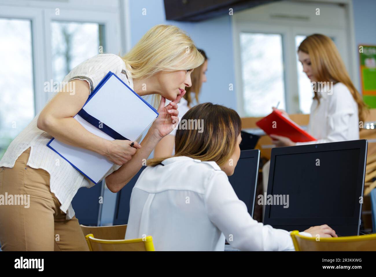manager watching over the shoulder of trainee using computer Stock ...