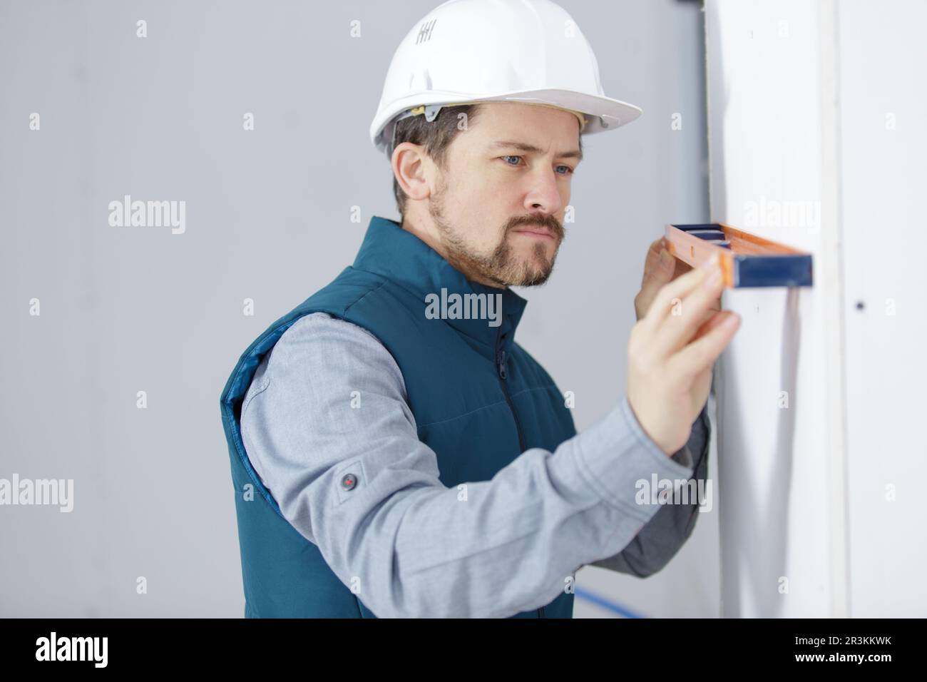 construction worker check the level on the wall Stock Photo - Alamy