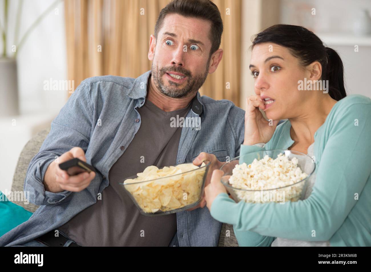 terrified couple watching a horror movie Stock Photo - Alamy
