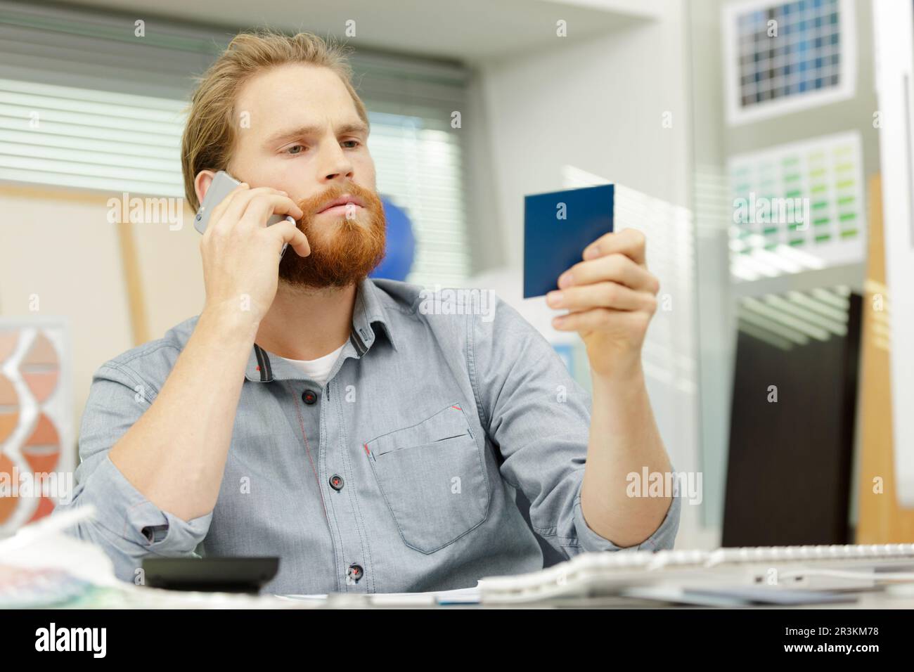 man holding color charts on telephone Stock Photo - Alamy