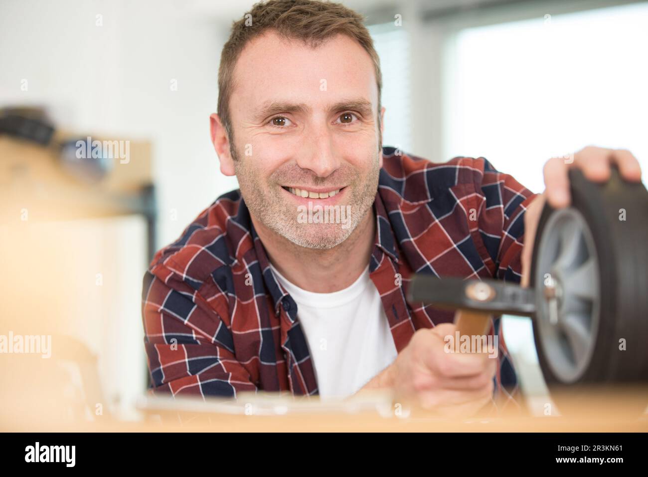 man using a hammer to tap trolley wheel Stock Photo - Alamy