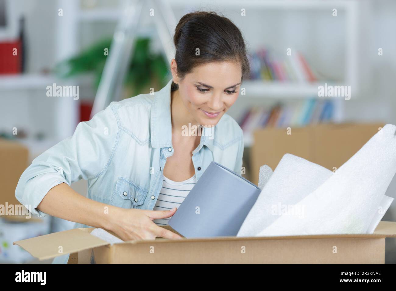 Woman unpacking parcel box hi-res stock photography and images - Alamy