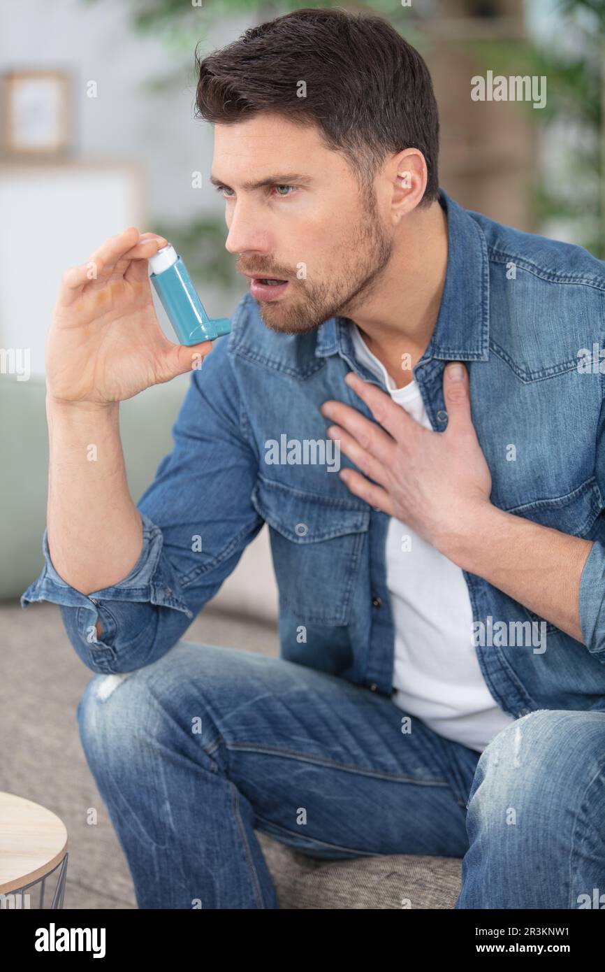 portrait of young man inhaling through inhaler Stock Photo - Alamy