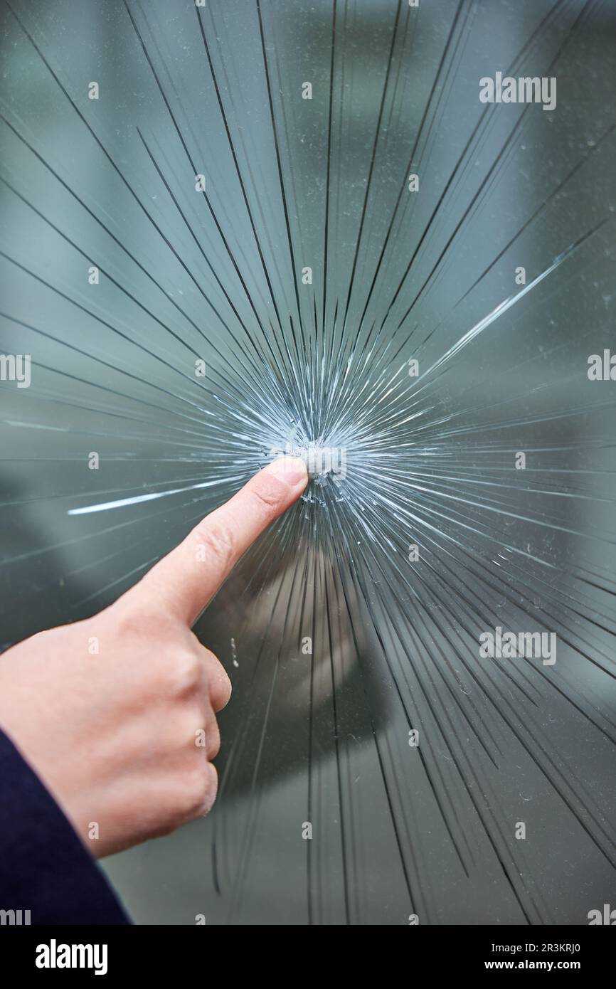Finger pointing at cracked window pane Stock Photo - Alamy