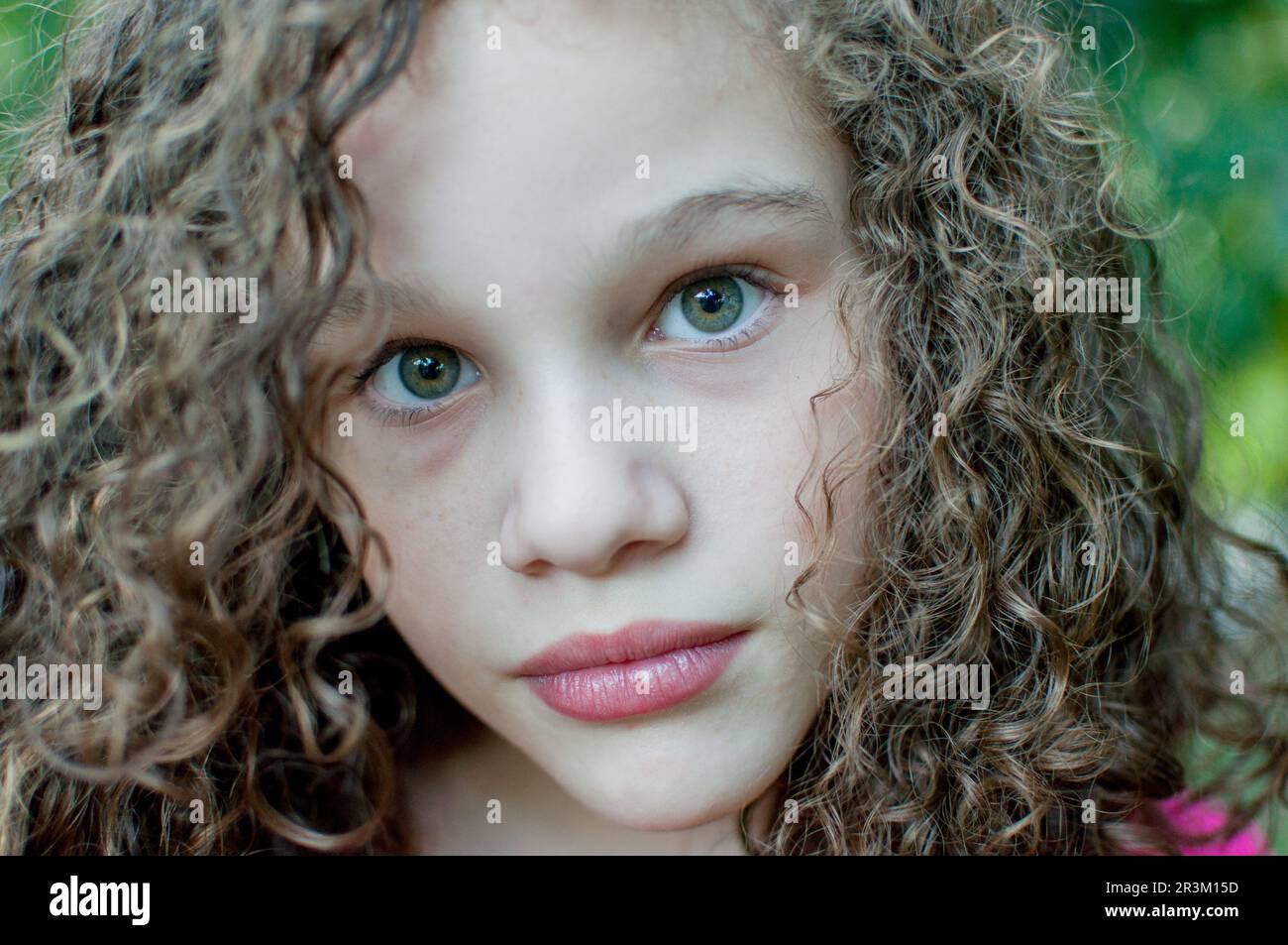 Portrait of girl with green eyes and curly hair looking at camera Stock Photo - Alamy