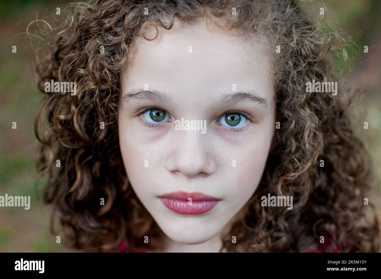 Little Girl With Green Eyes And Curly Hair