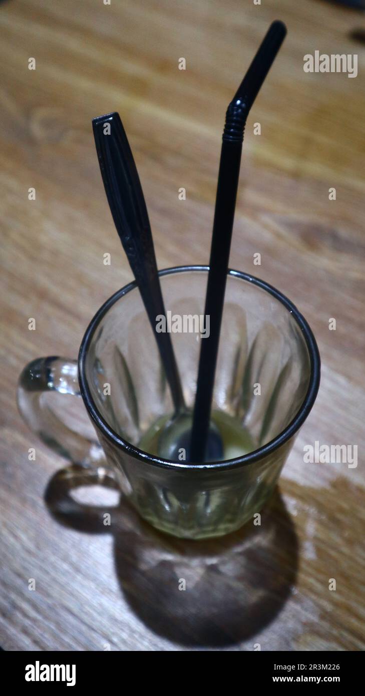metal spoon and plastic straw in an empty glass in a cafe Stock Photo ...