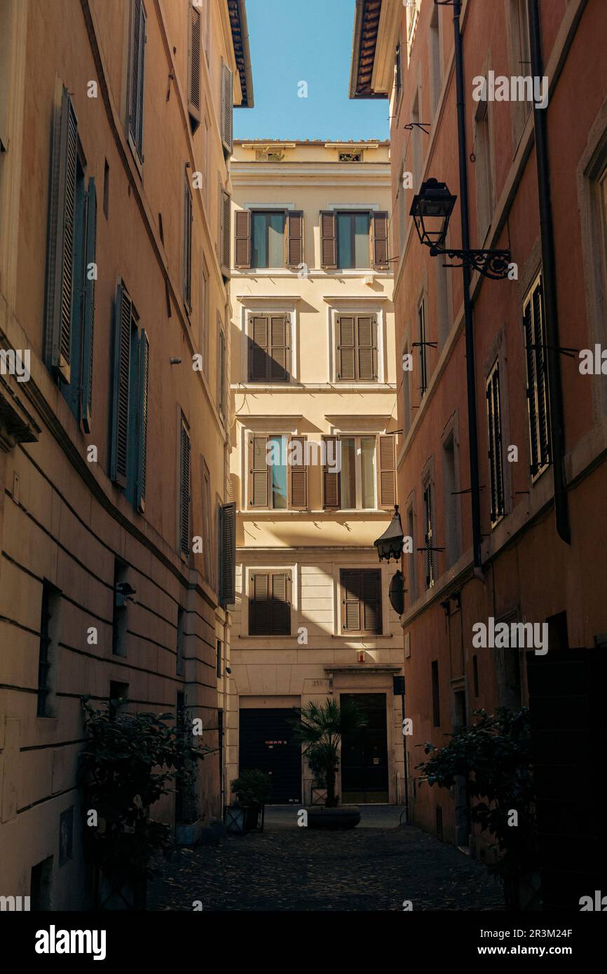 A narrow alley with a building on the left and the windows on the right ...